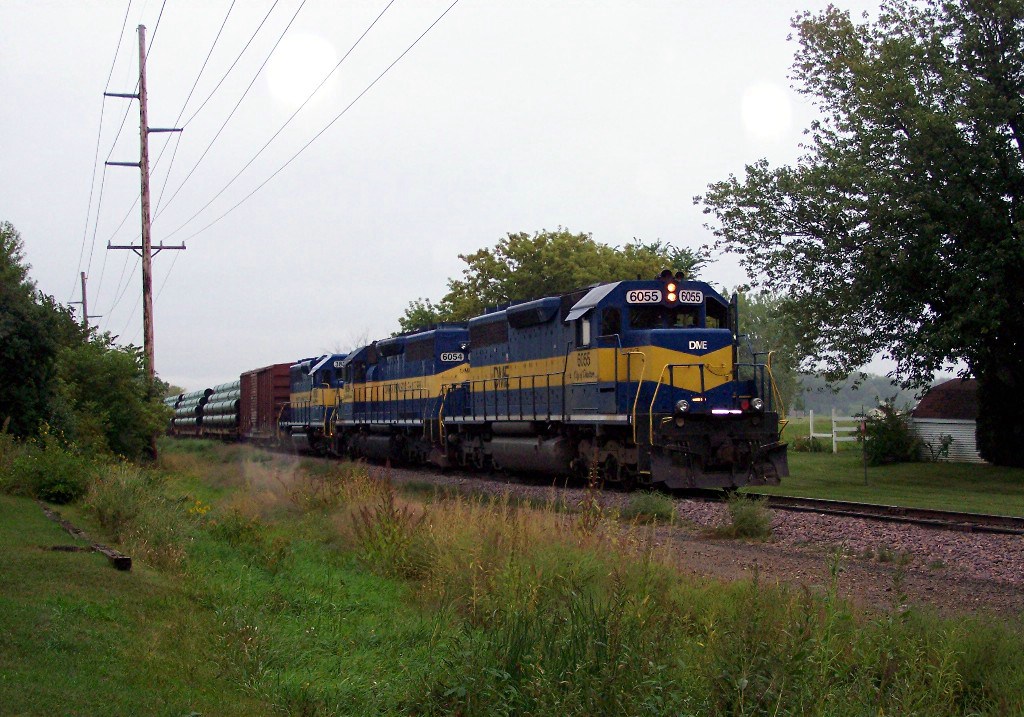 DME 6055 is westbound on main track east of Waseca yard.